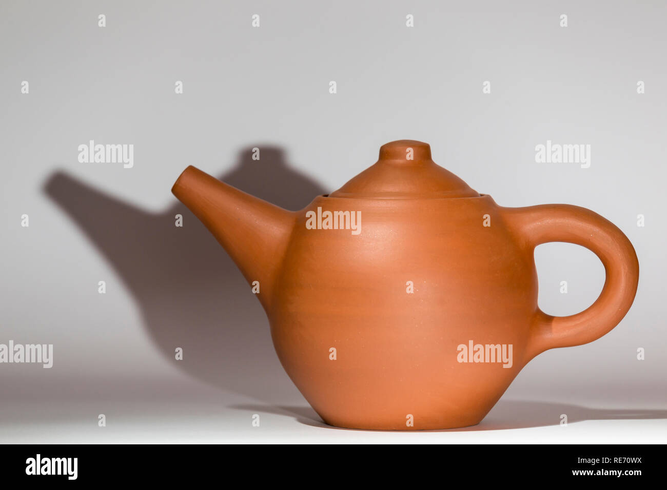 view of a red clay teapot isolated on white background, but ...