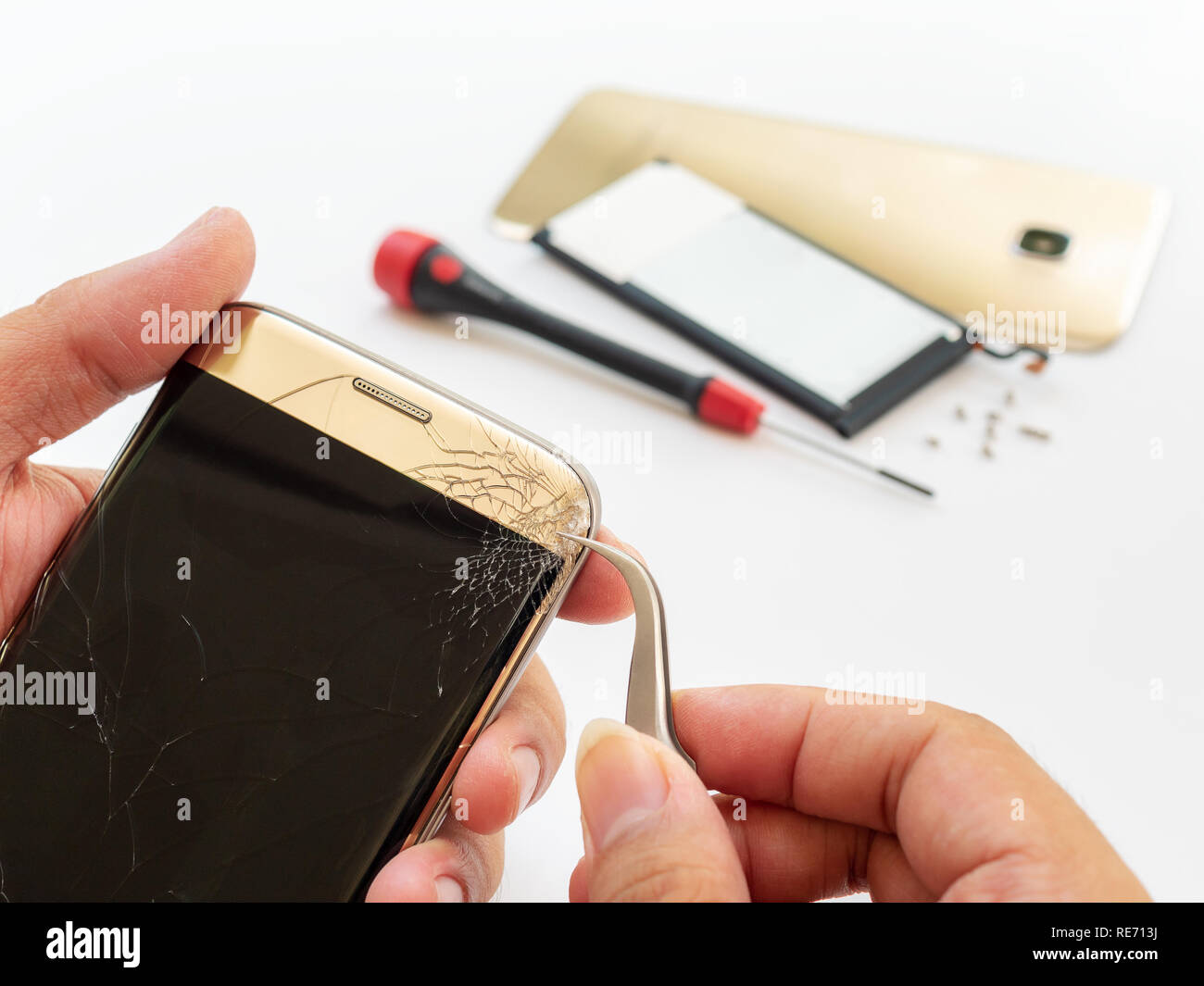 Close-up of technician hand taking off cracked smartphone screen for ...
