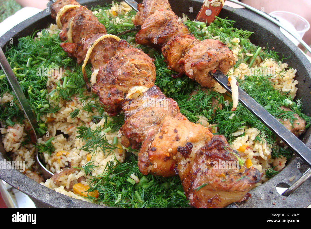 Barbecue meat on skewers and white rice in an iron pot. Top view, flat ...