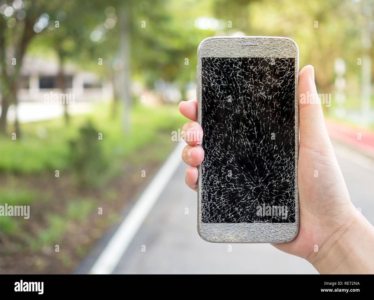 Close-up image of human hand holding old broken and cracked screen ...