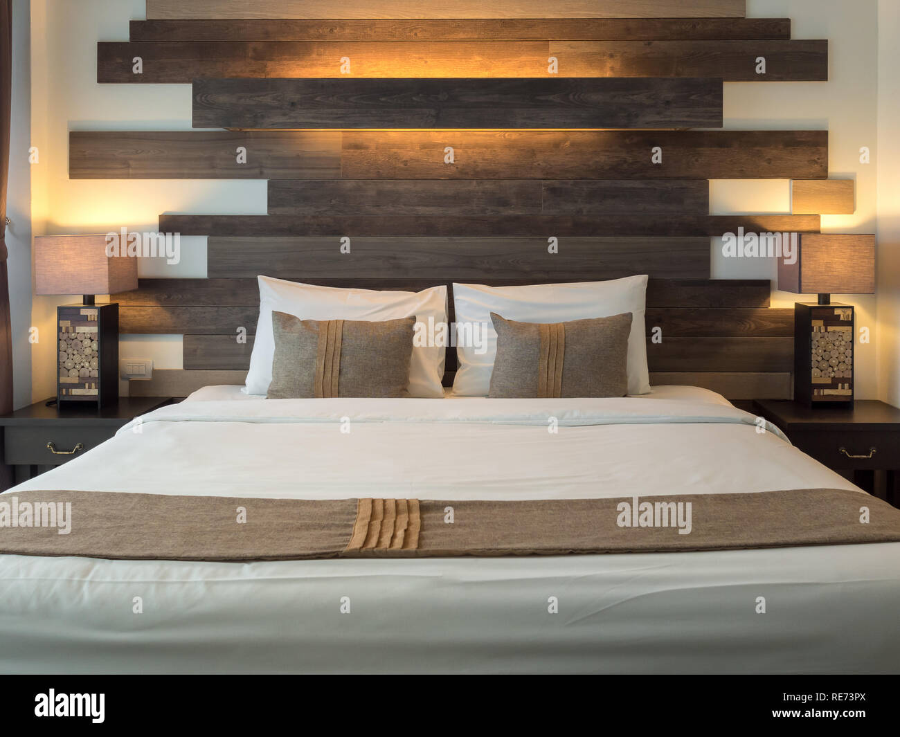 Empty double bed and lamp on wooden table on side of bed in luxury and ...
