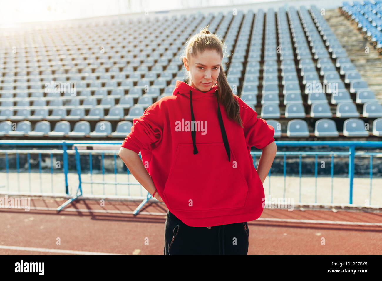 Beautiful girl in sportswear standing on the running track and ...