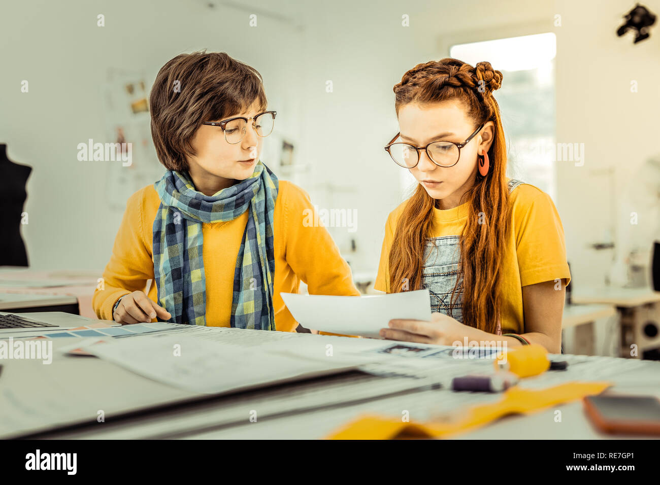 Brother and sister wearing glasses learning to sew clothes Stock Photo ...