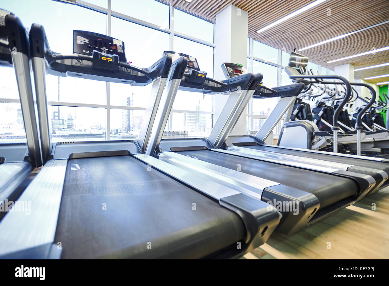 Image of modern treadmills standing in a row against the big window in ...