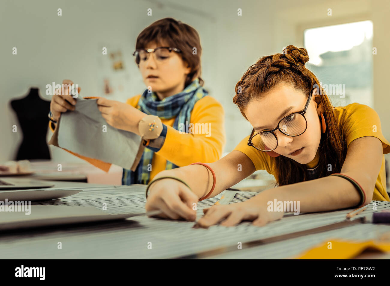 Future fashion designers using rulers while measuring fabrics Stock ...
