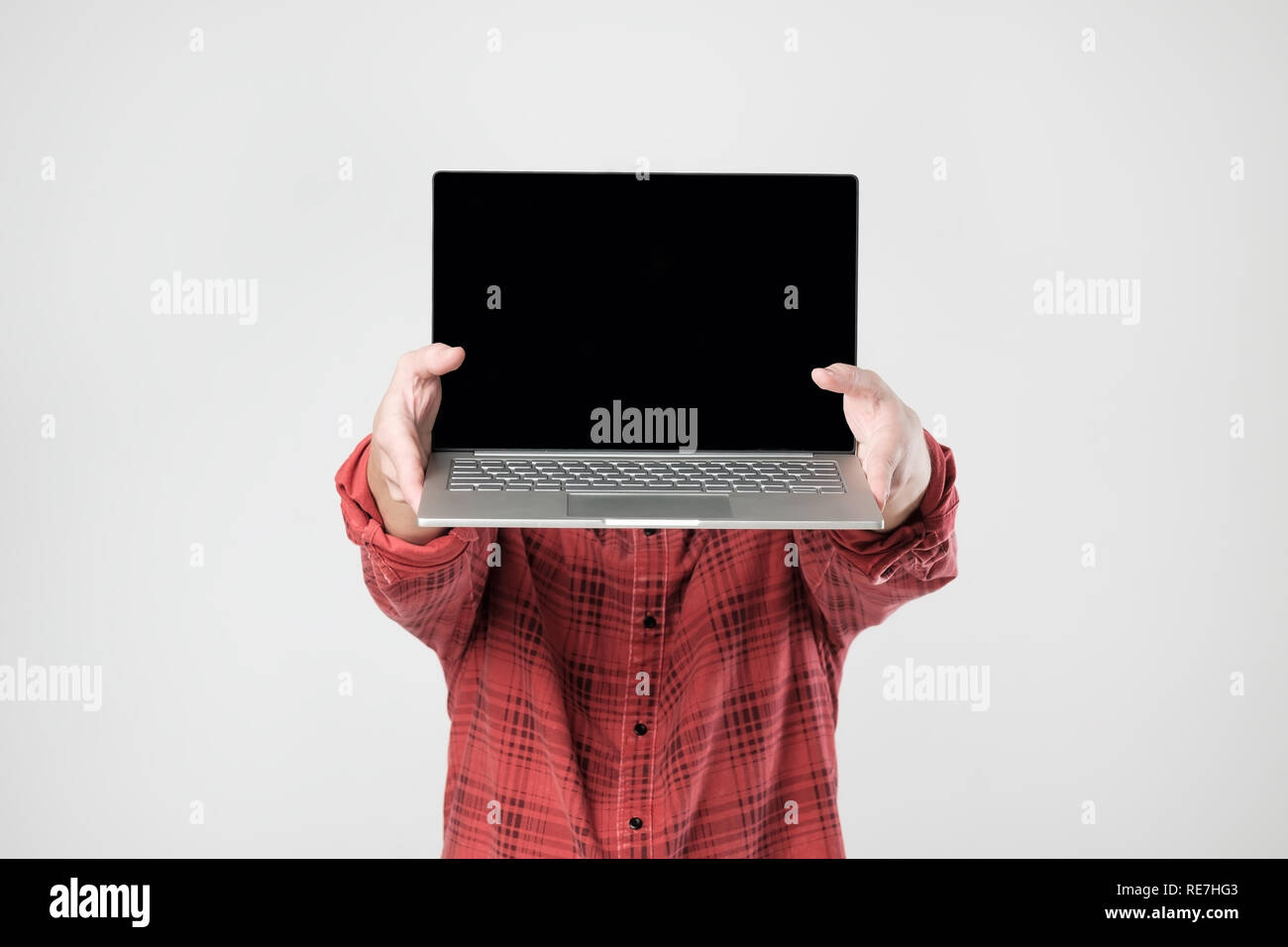 man carrying laptop and showing screen of it standing hiding his face ...