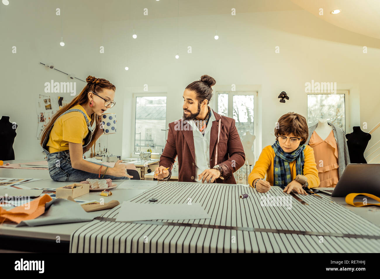Bearded tutor in clothes design teaching schoolchildren Stock Photo - Alamy