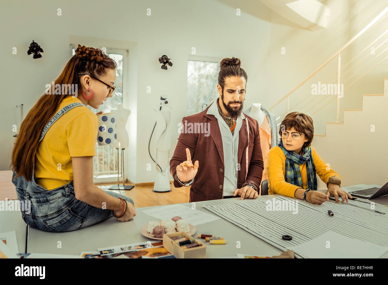 Father working as designer teaching his children drafting patterns ...