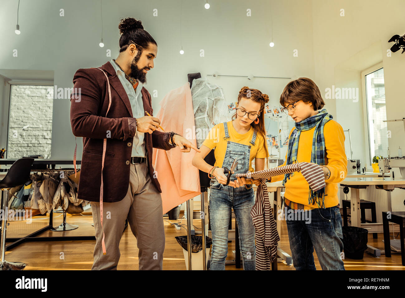 Two children attending design school holding striped fabric Stock Photo ...