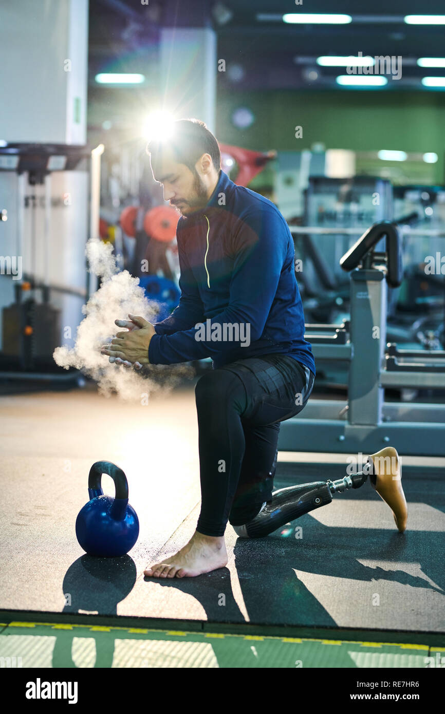 Serious handsome young bearded man with prosthetic leg standing on one ...