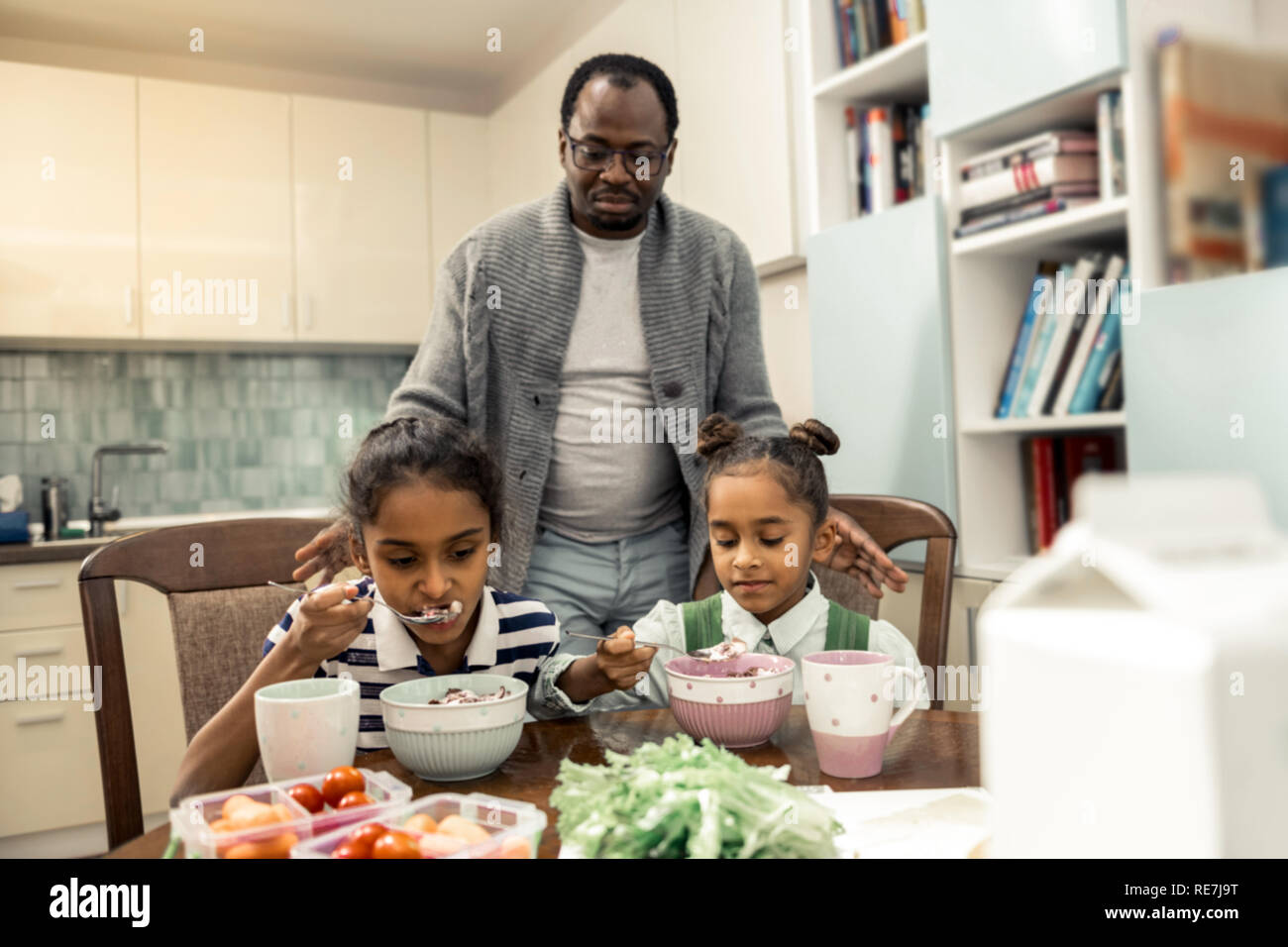 Caring loving father giving breakfast for his beautiful twins Stock ...