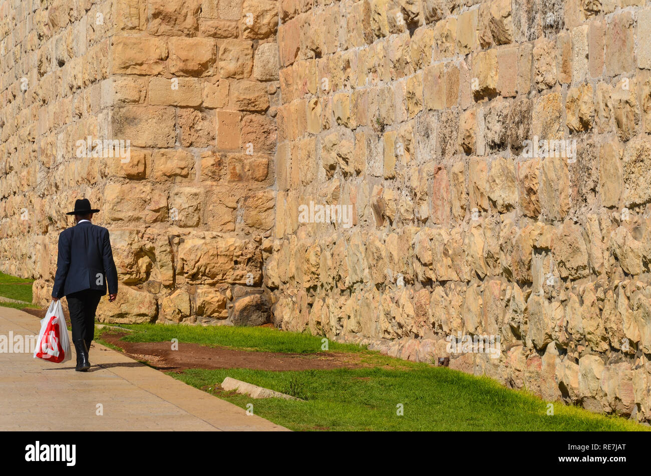 Orthodox Jewish man walking near the city walls of Jerusalem Stock ...