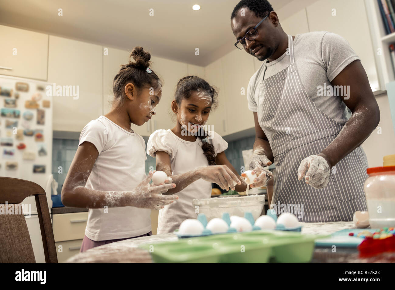 Two girls feeling excited while beating eggs for cooking pie Stock ...