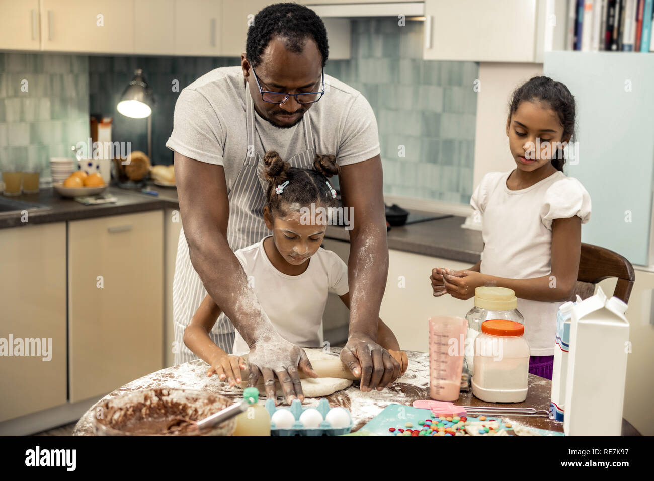 Father rolling out pastry for pie with his helpful daughter Stock Photo ...