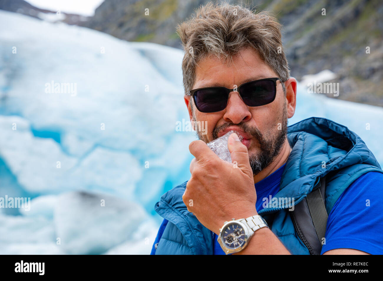 Man trying blue ice piece of Svartisen Glacier, Norway Stock Photo - Alamy