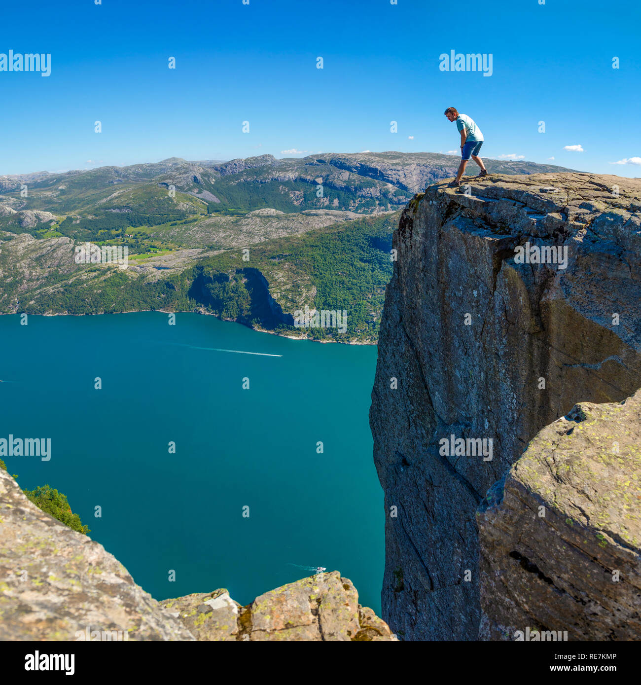 Hiker standing on Preikestolen and looking on the fjerd, Preikestolen ...