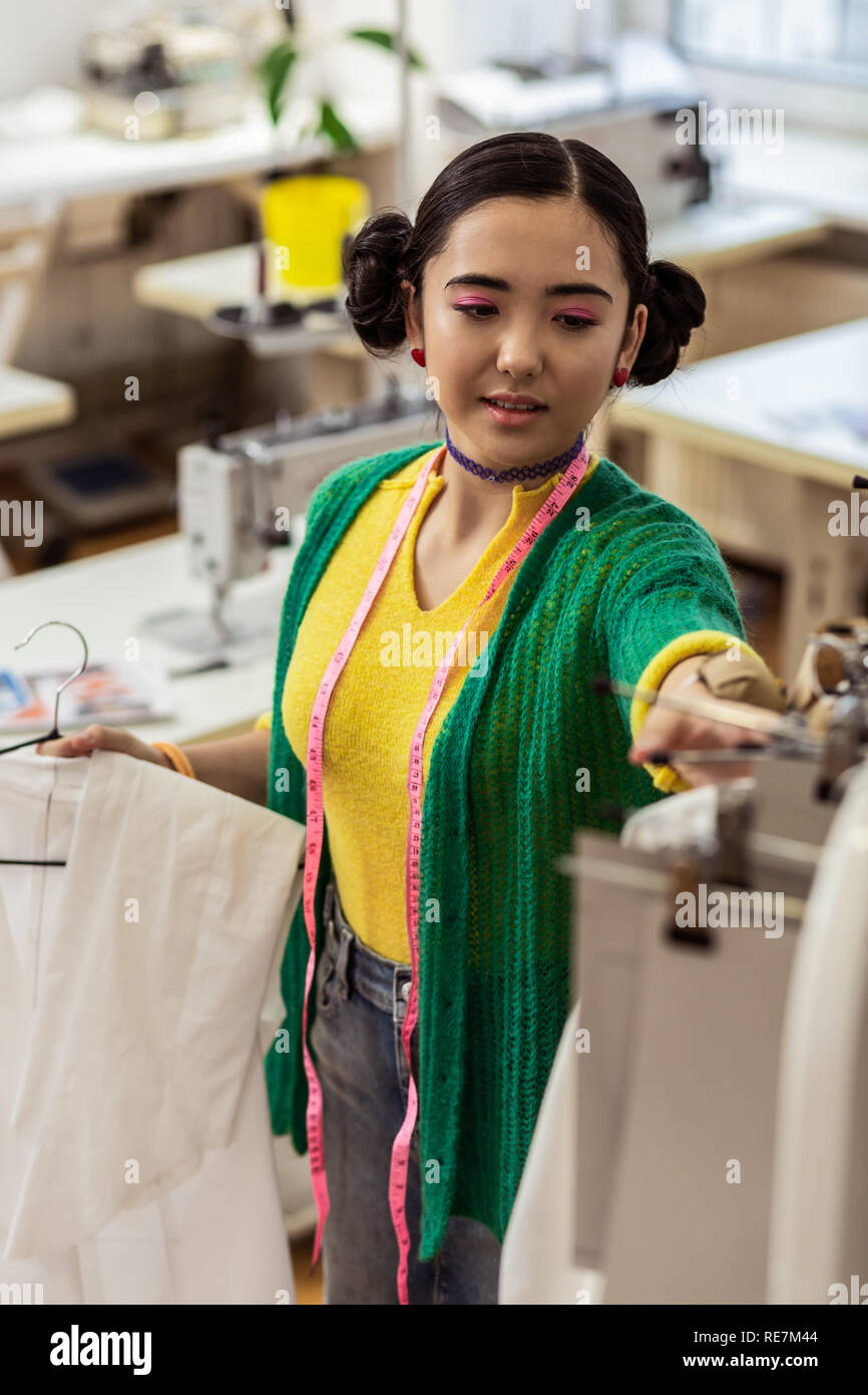 Cute asian fashion designer with bright bracelets feeling contented ...