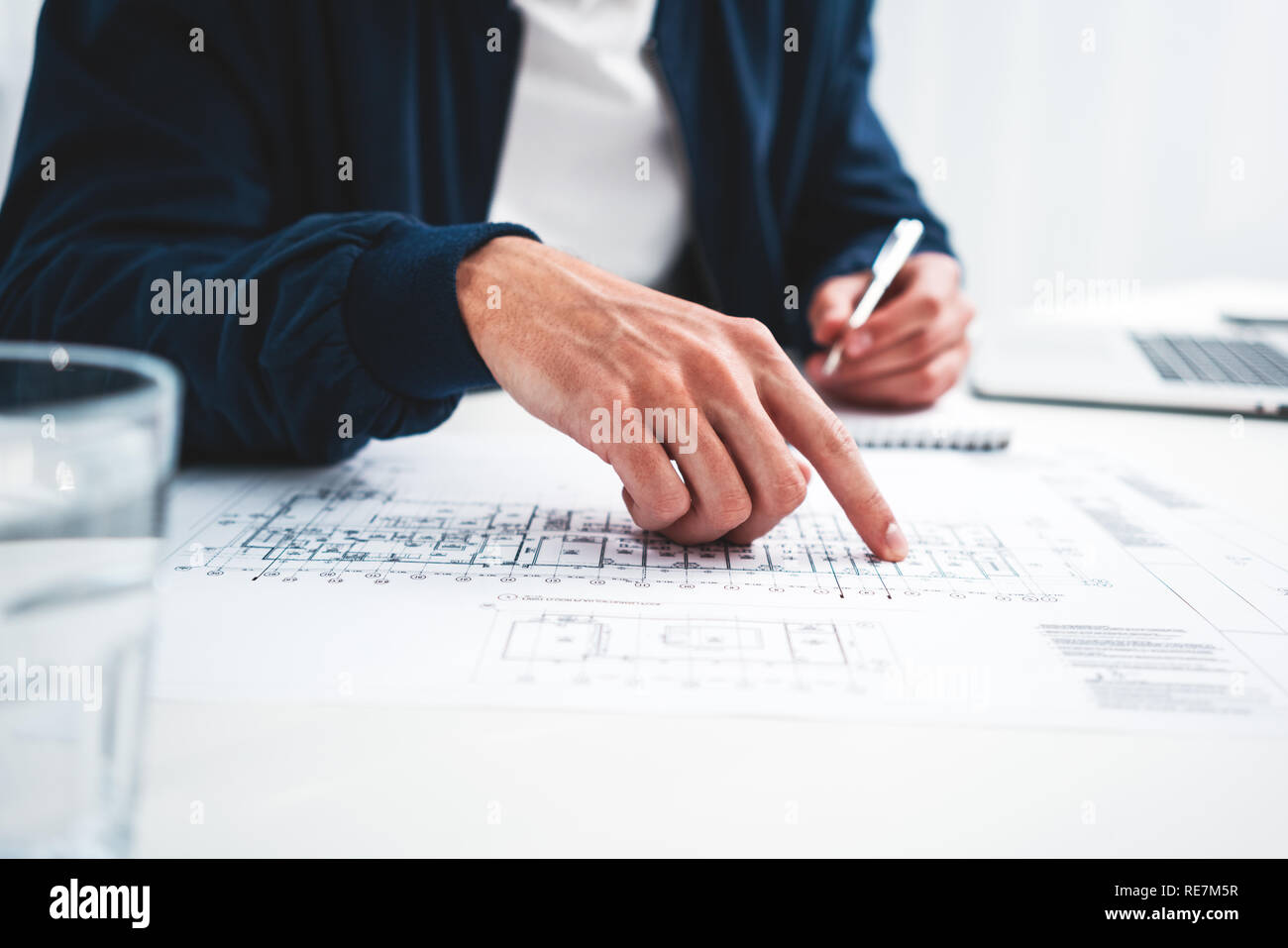 Coworker man using laptop and printer blueprint in modern office. Graph ...