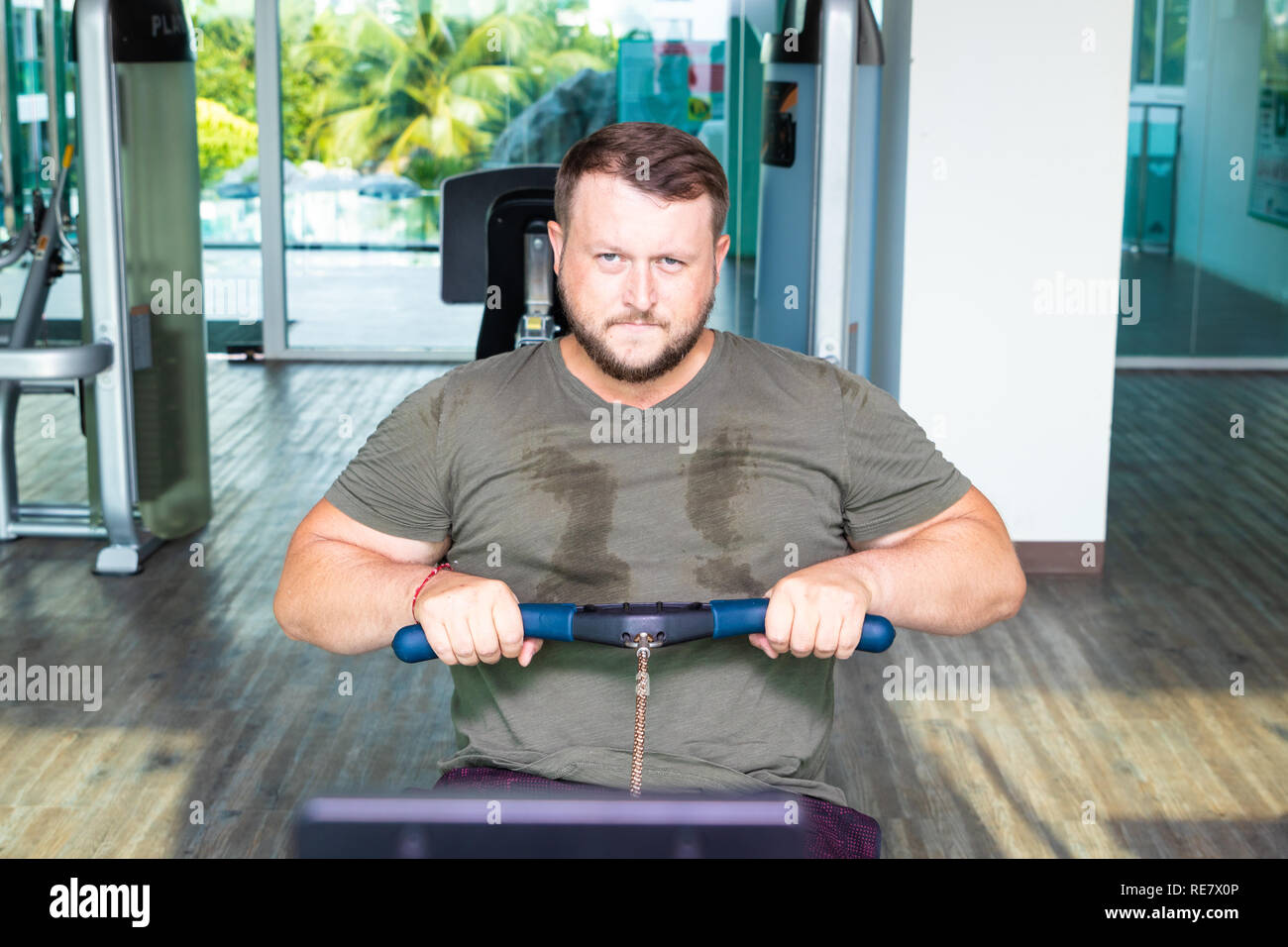 Sweating chubby man walking on running track, warming up on gym ...