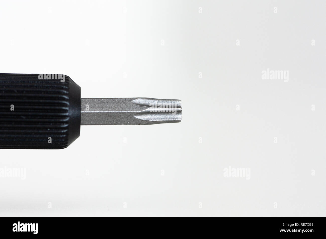 Small screwdriver head close up macro black handle isolated against ...
