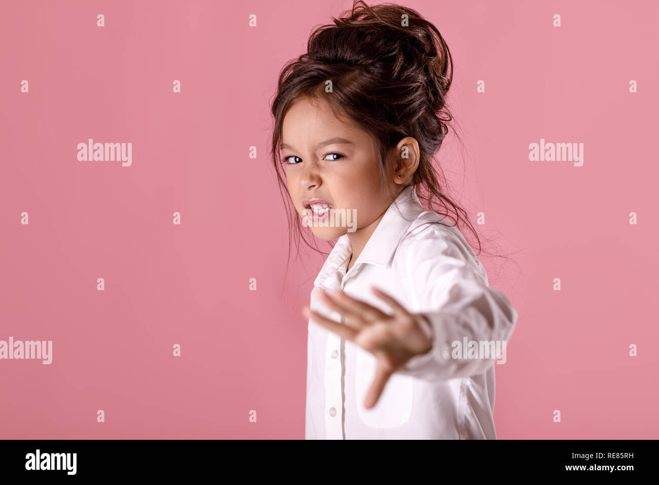 Cute scared little girl in white shirt making stop gesture Stock Photo ...