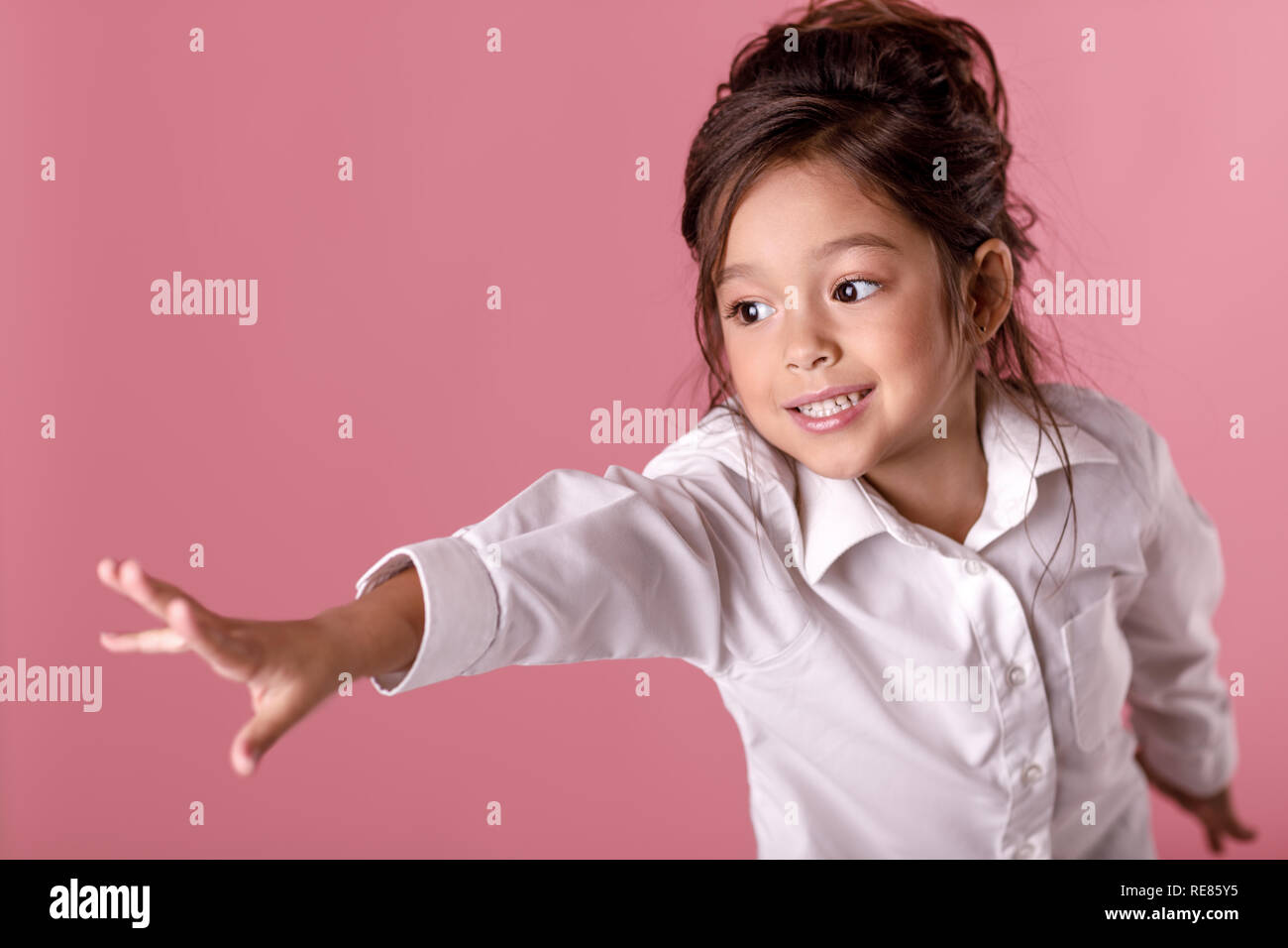 Cute smiling little girl in white shirt reaching for something Stock ...