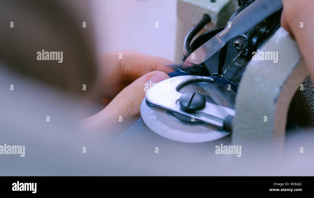 Professional male skinner, furrier using special sewing machine for ...