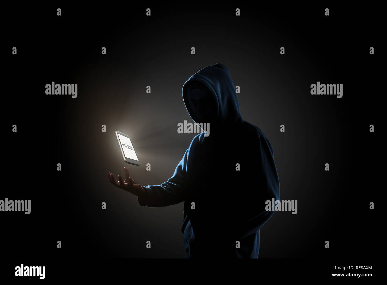 White smartphone with text "HACKER" on screen floating above of hacker ...