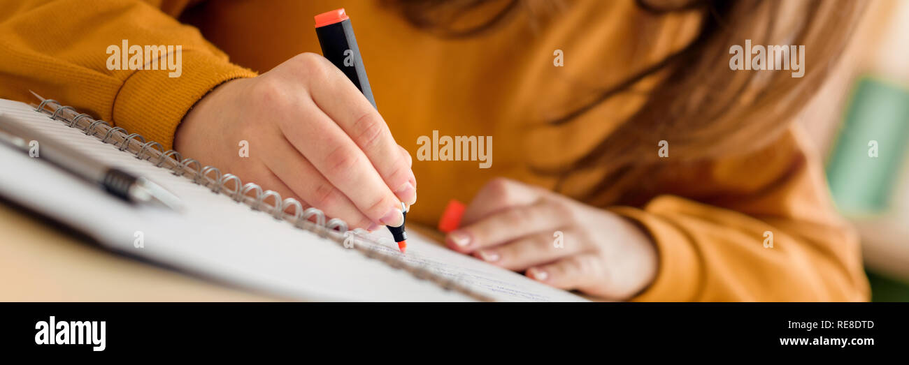 Young unrecognisable female college student in class, taking notes and ...
