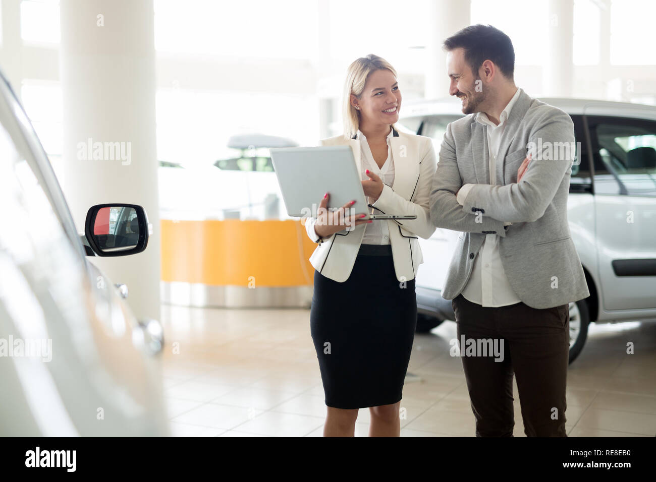 Professional salesperson selling cars at dealership to buyer Stock ...