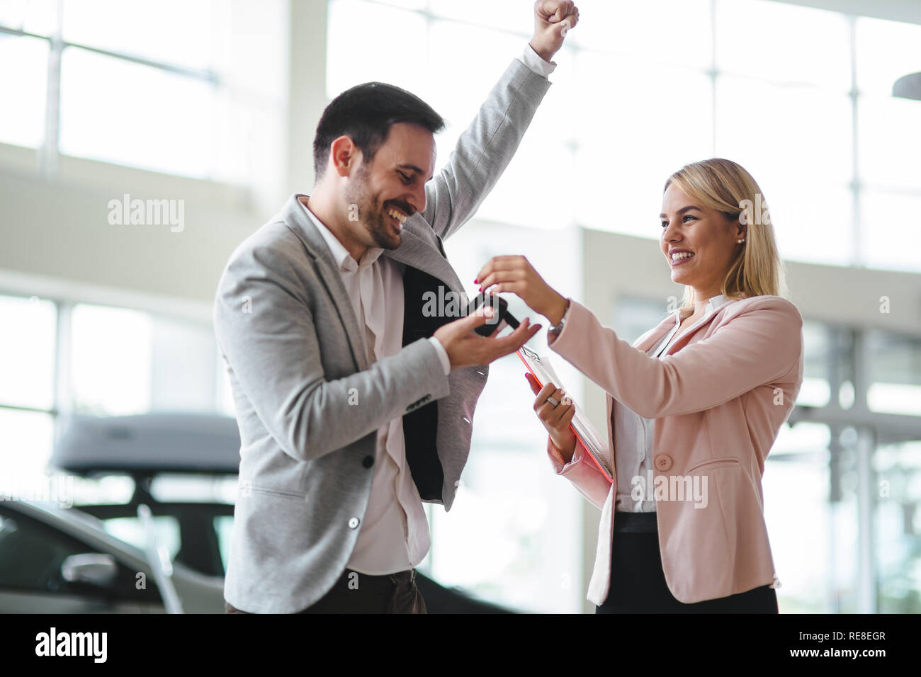 Professional salesperson during work with customer at car dealership ...