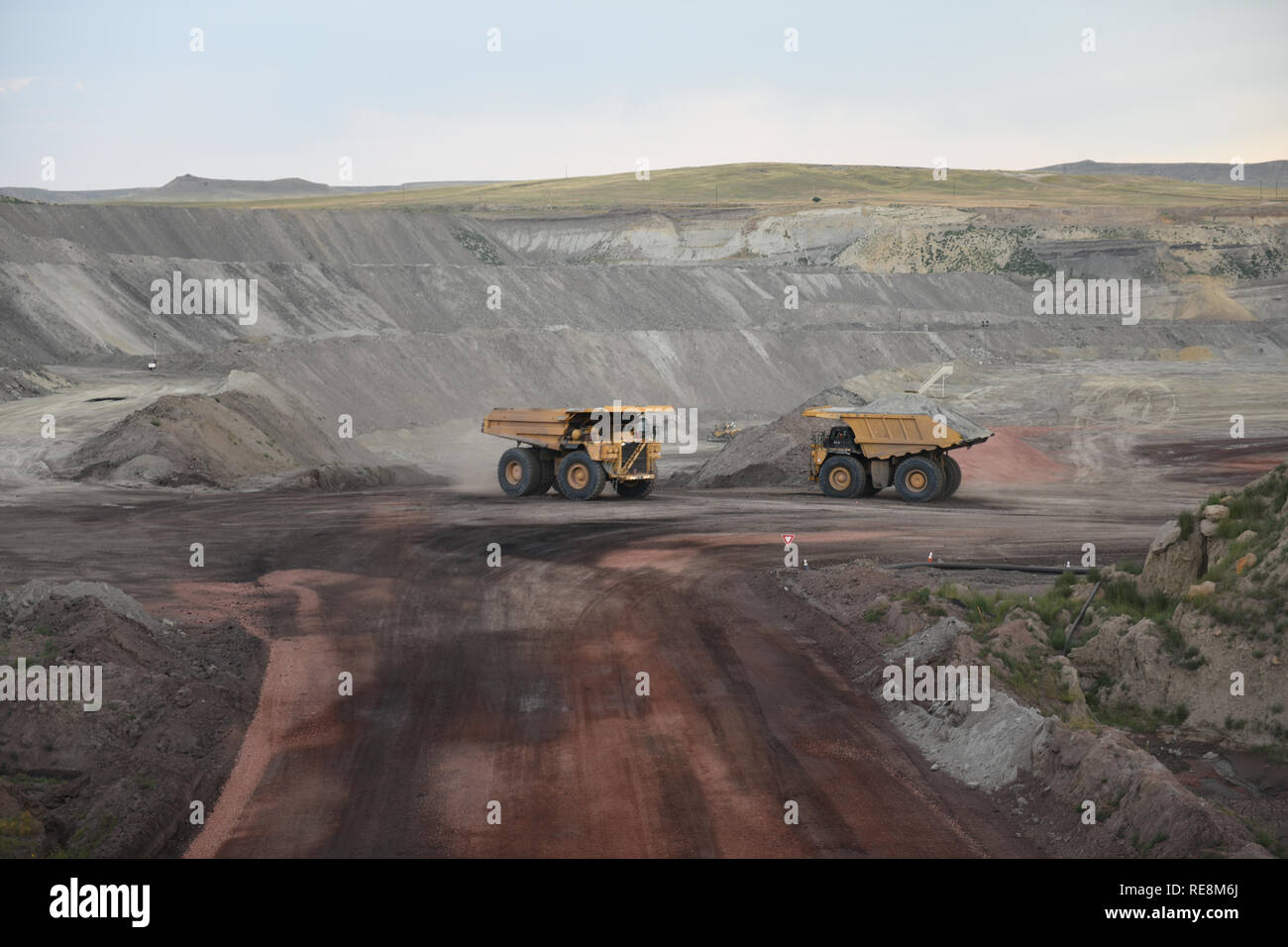 Giant sized yellow coal mining loader trucks passing each other inside ...