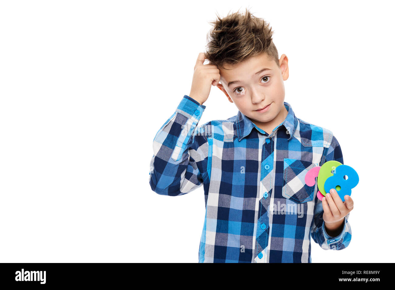 Cute boy with dyscalculia holding large colorful numbers and scratching ...