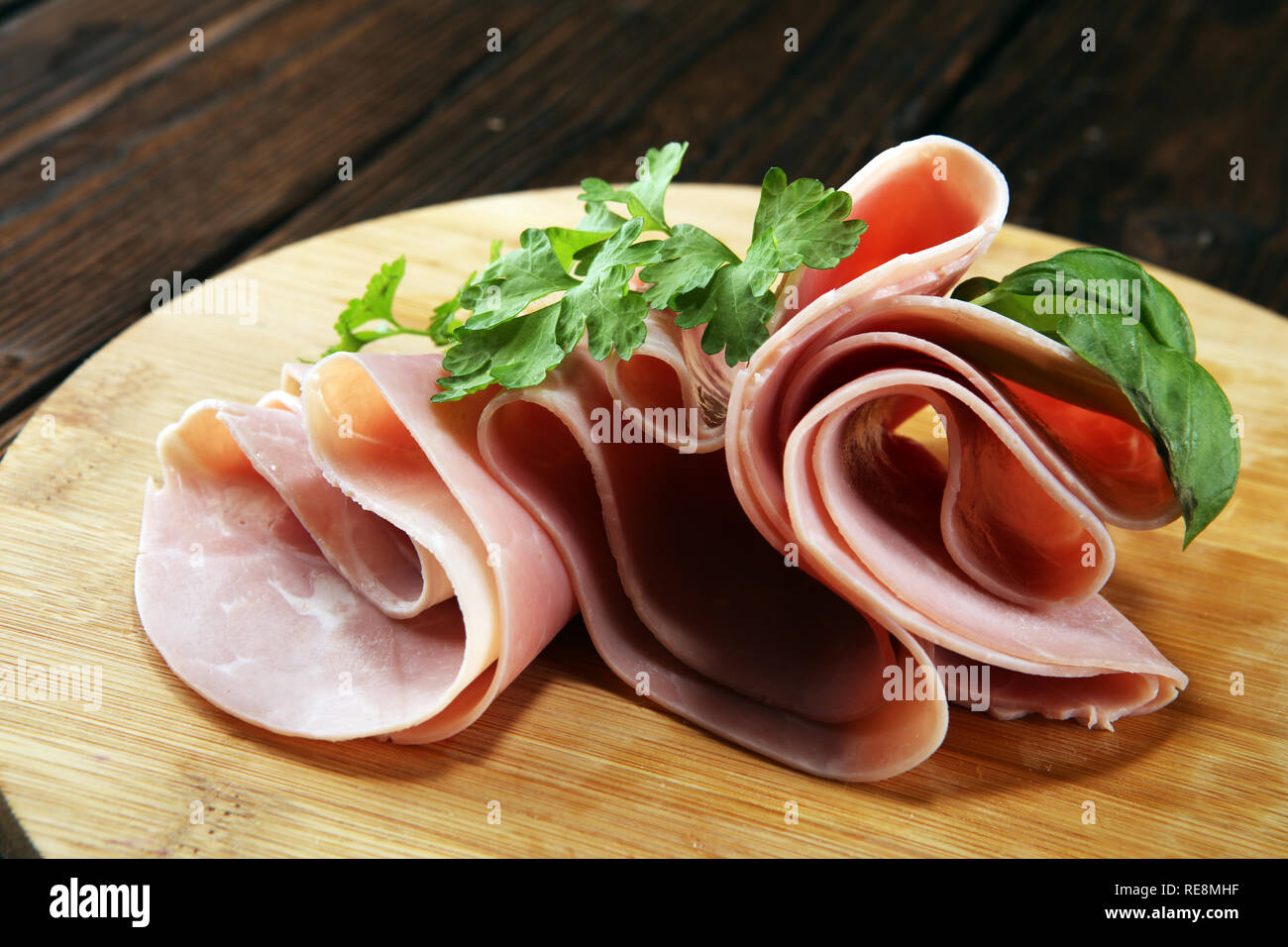 Sliced ham with parsley on table. Fresh prosciutto. Pork ham sliced ...
