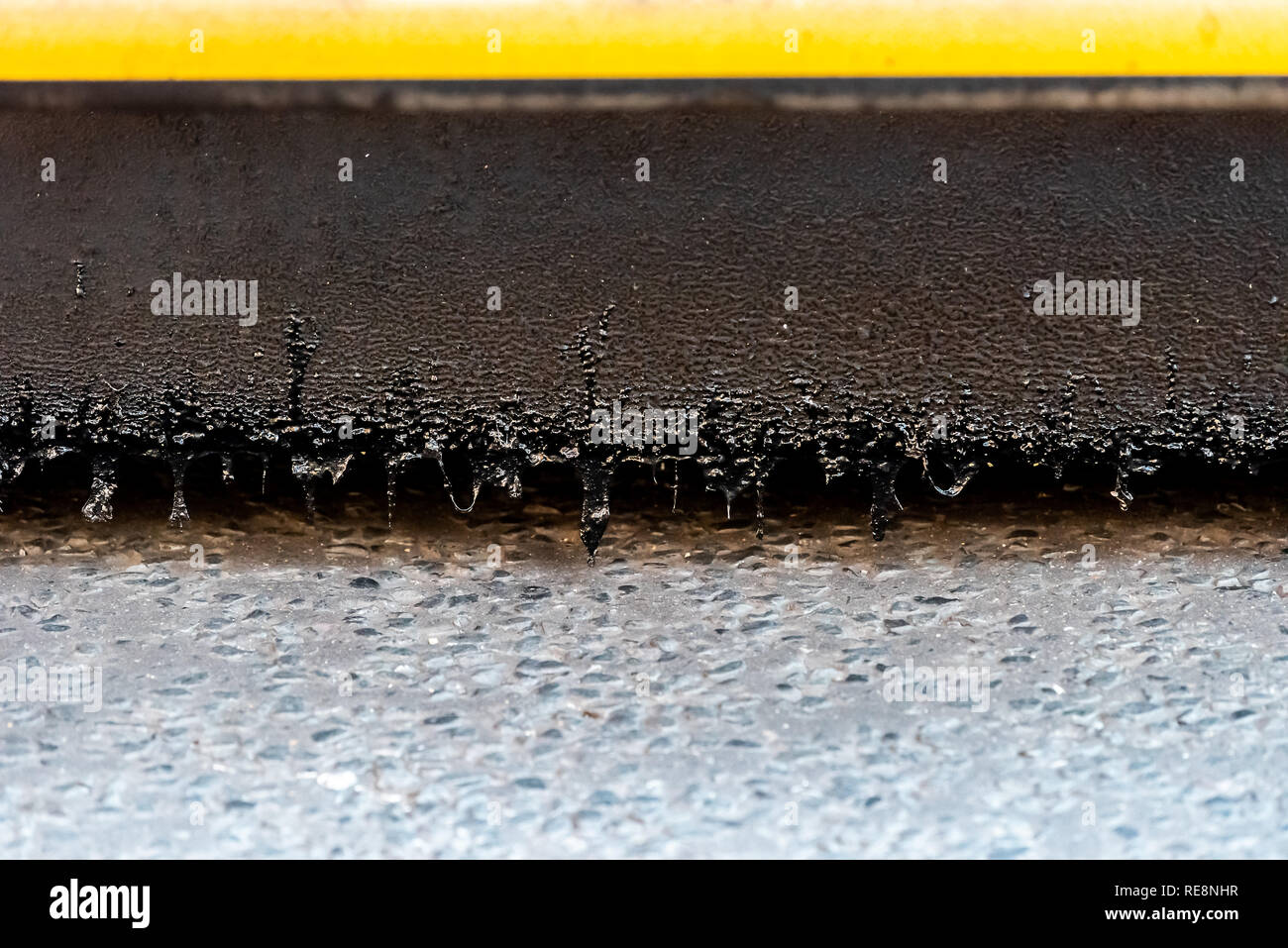 Abstract macro closeup of asphalt pavement machine with black tar on ...