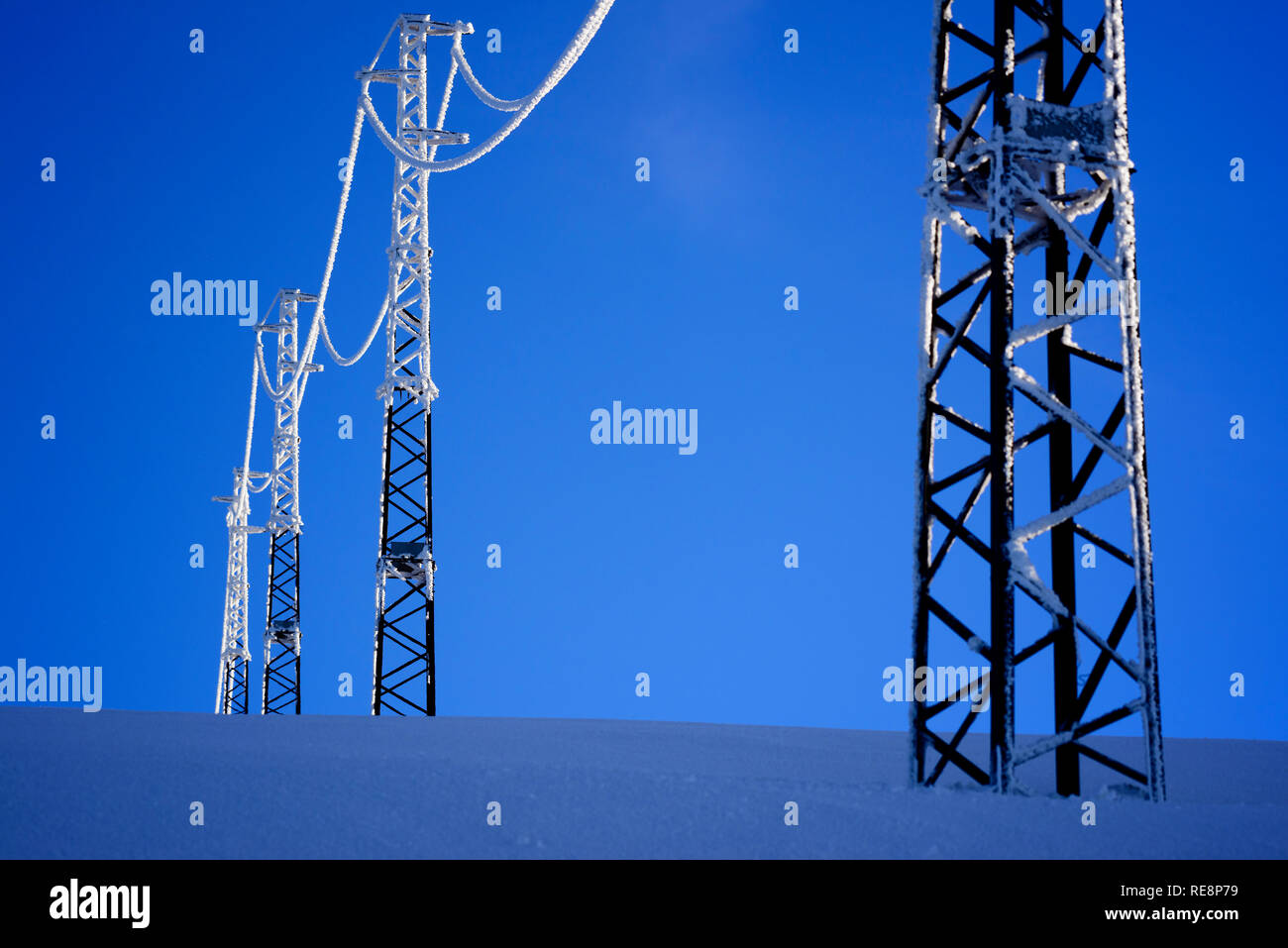 High voltage pylons covered with snow Stock Photo - Alamy