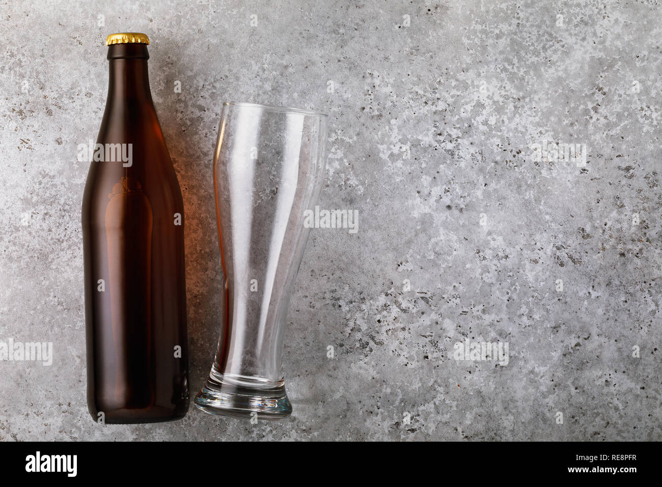 Full bottle of beer and empty glass on the table with copy space, top ...