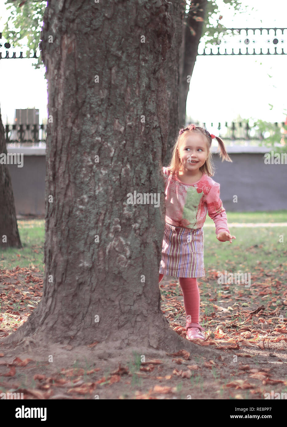happy little girl playing hide and seek in the city Park Stock Photo ...