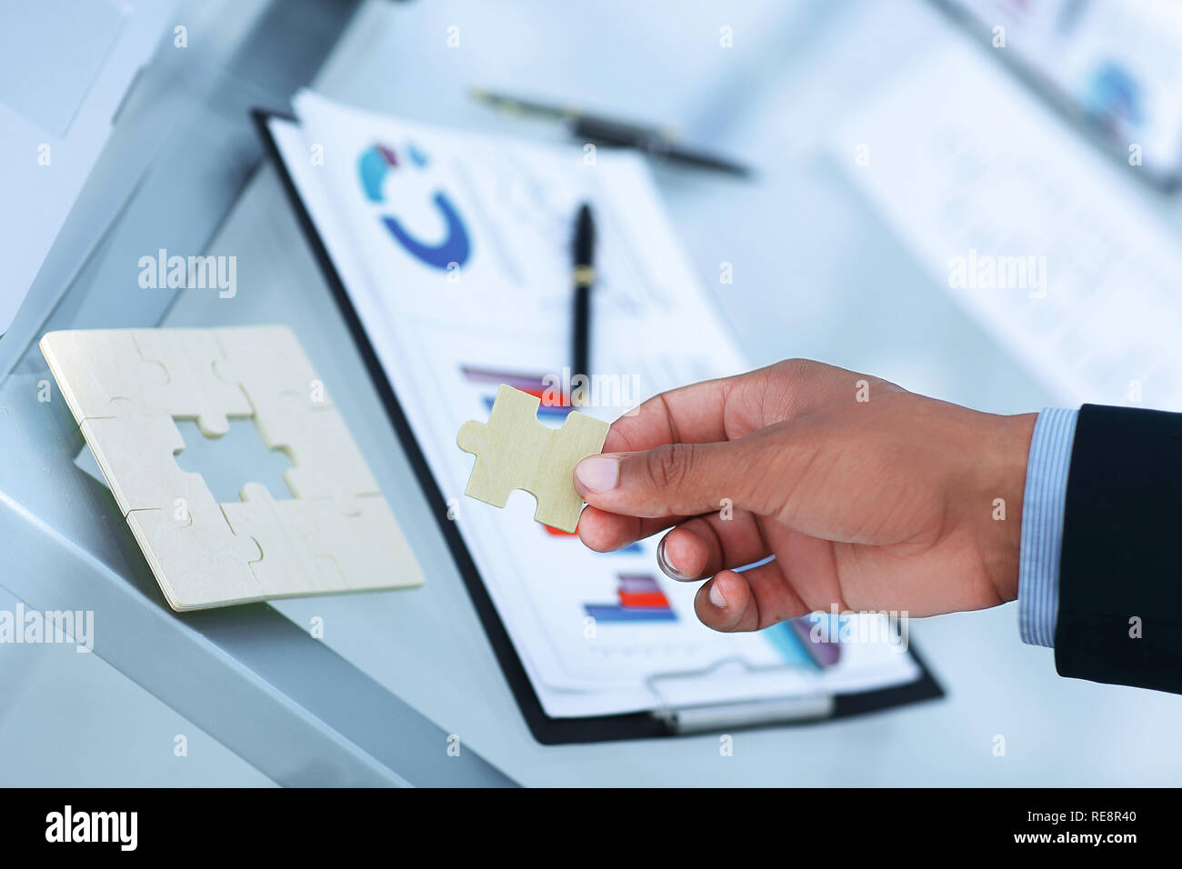 closeup. the businessman is a puzzle,sitting behind a Desk Stock Photo ...