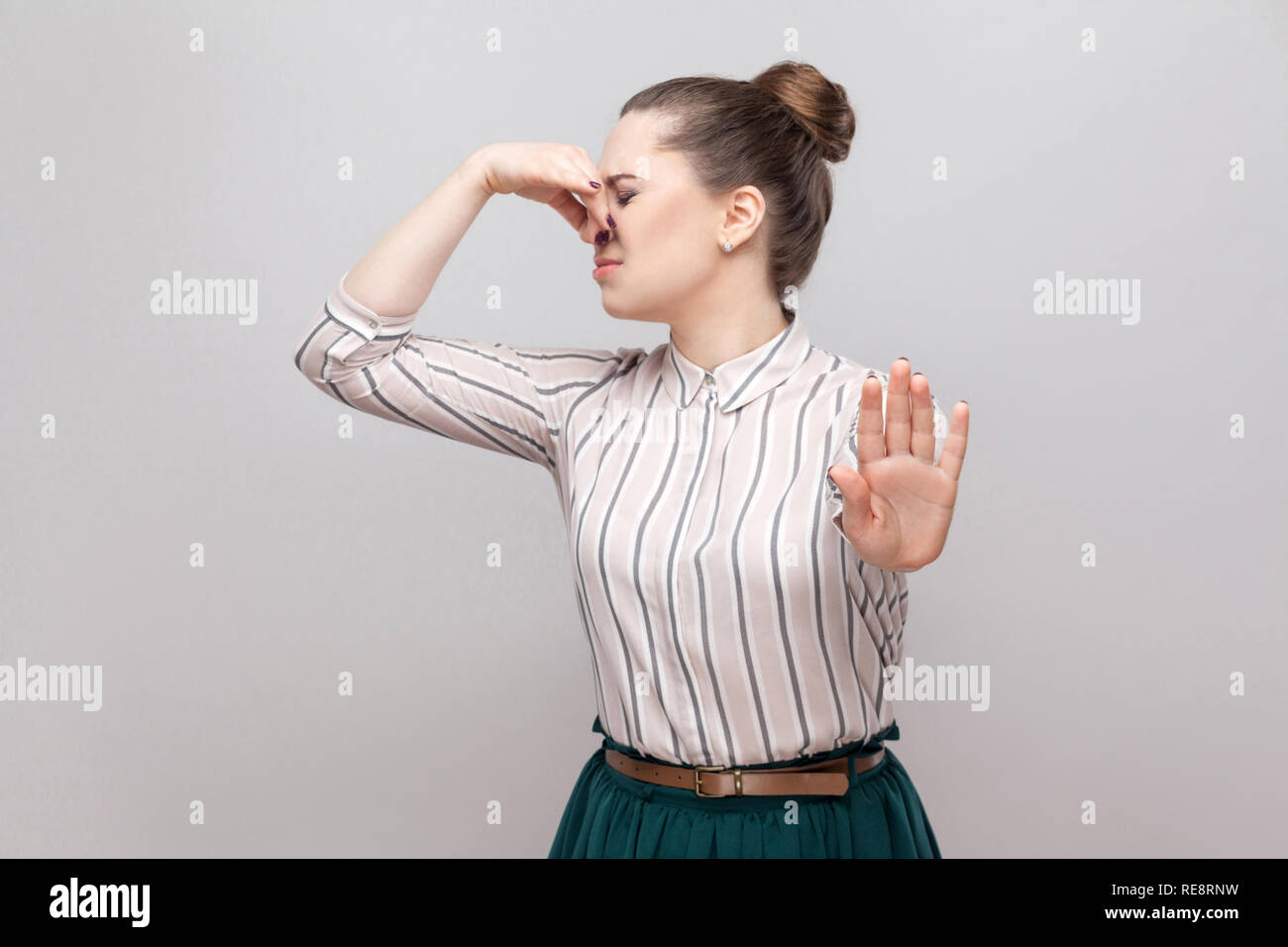Portrait of ignoring beautiful young woman in striped shirt with makeup ...