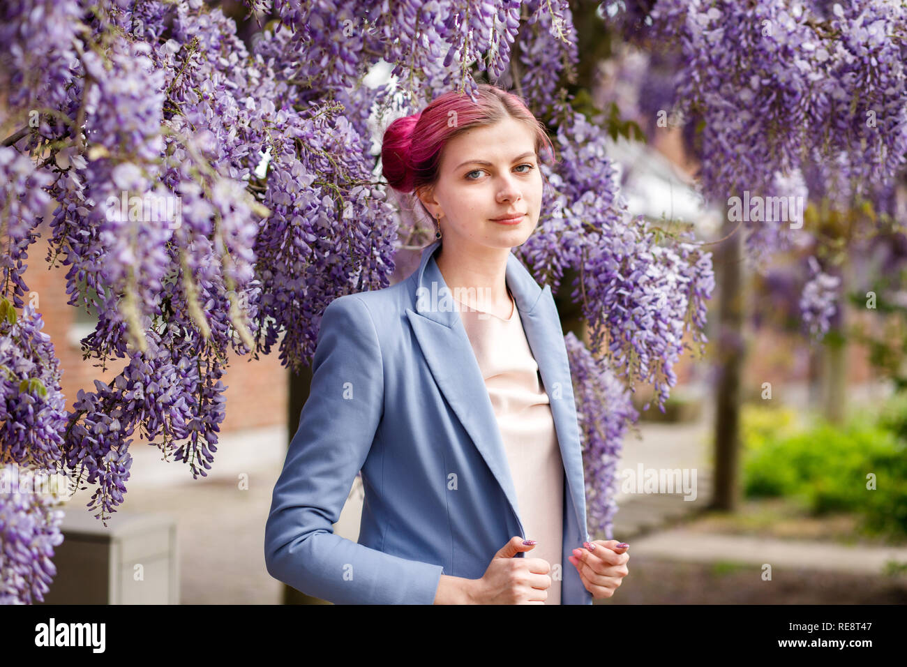 Gentle refined woman in the garden of beautiful wisteria trees Stock ...