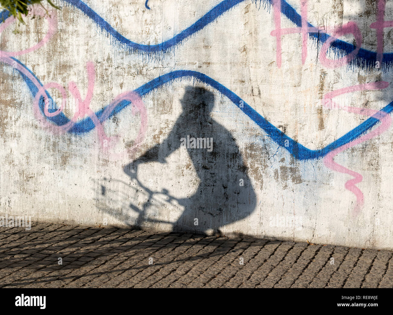shadow of man on bicycle on city concrete wall with graffiti Stock ...