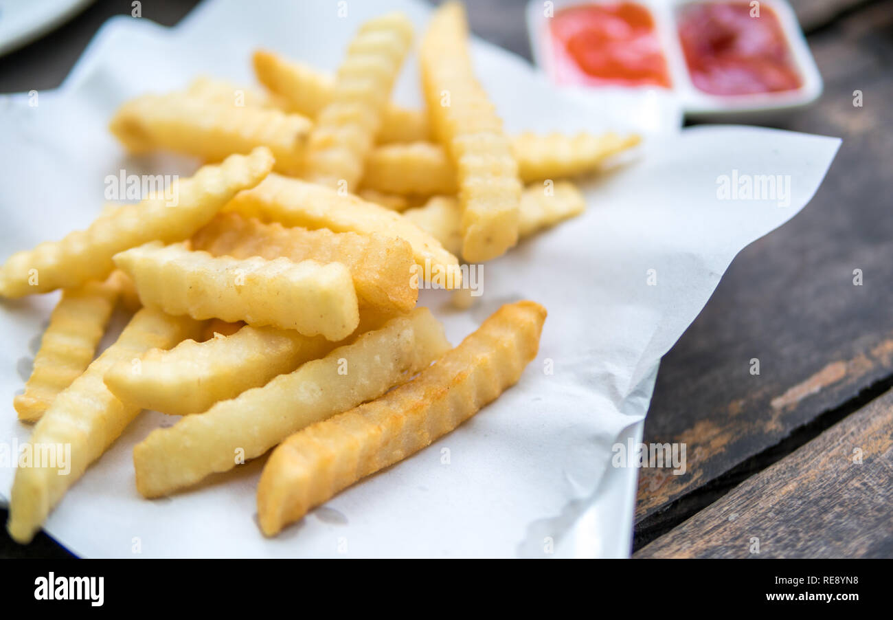 potatoes fries with sauce on a white paper Stock Photo - Alamy