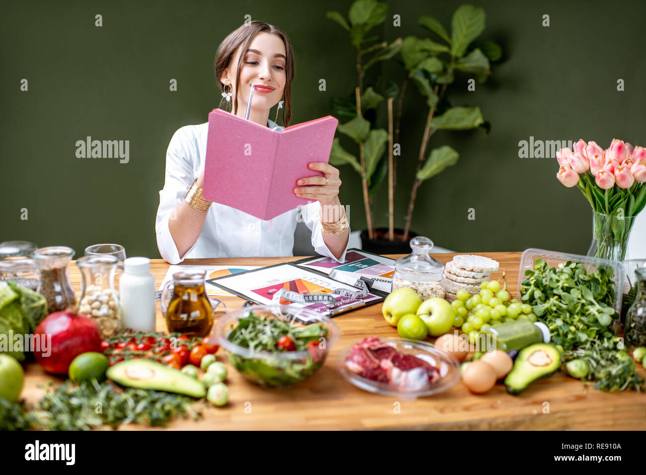 Woman dietitian in medical uniform working on a diet plan sitting with ...
