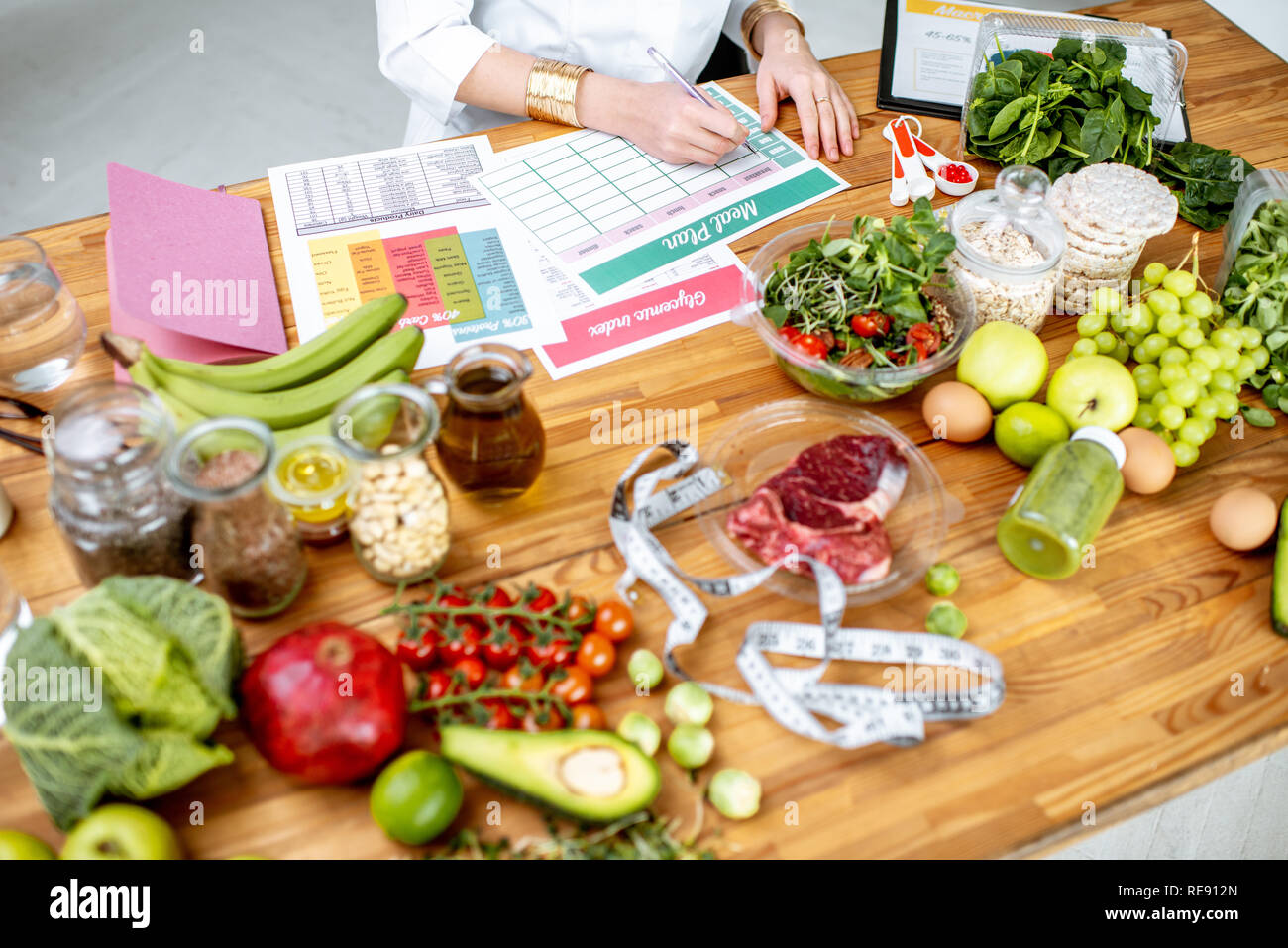Dietitian writing a diet plan, view from above on the table with ...