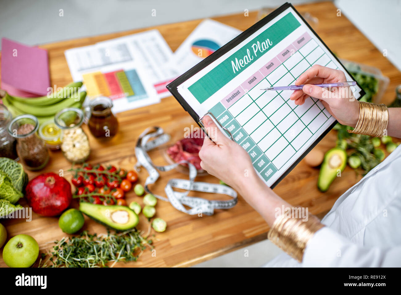 Dietitian writing a diet plan, view from above on the table with ...