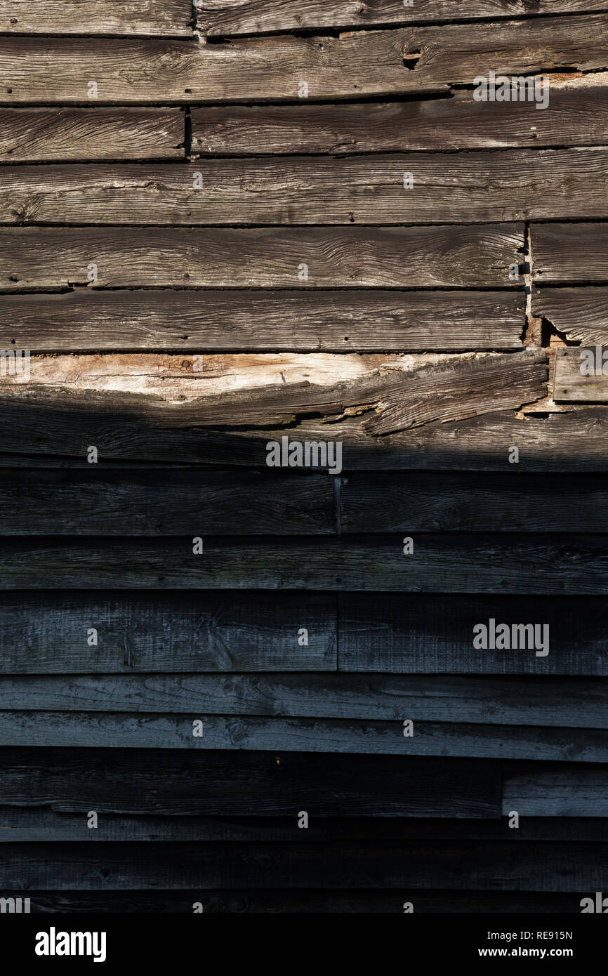 Feathered board wood on side of farm building. Weathered deteriorating ...