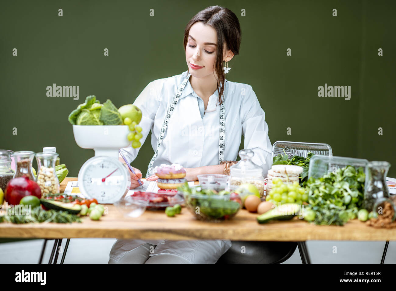 Woman dietitian in medical uniform working on a diet plan sitting with ...