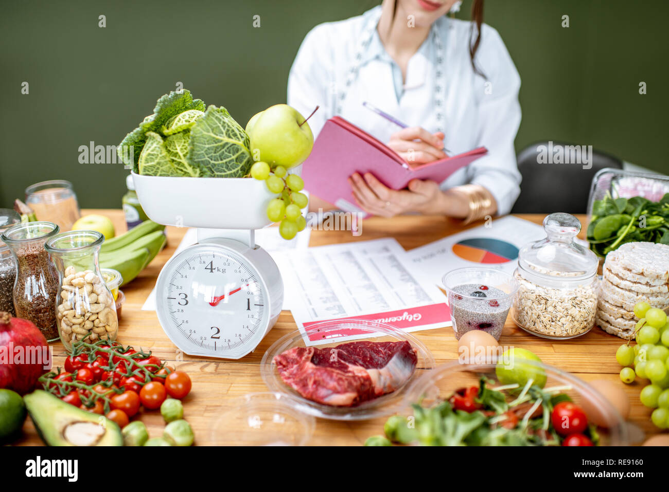 Woman dietitian working on a diet plan sitting with various healthy ...