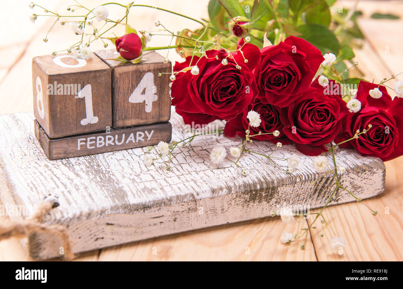 Wooden calendar with fourteenth of February date and fresh bouquet of ...